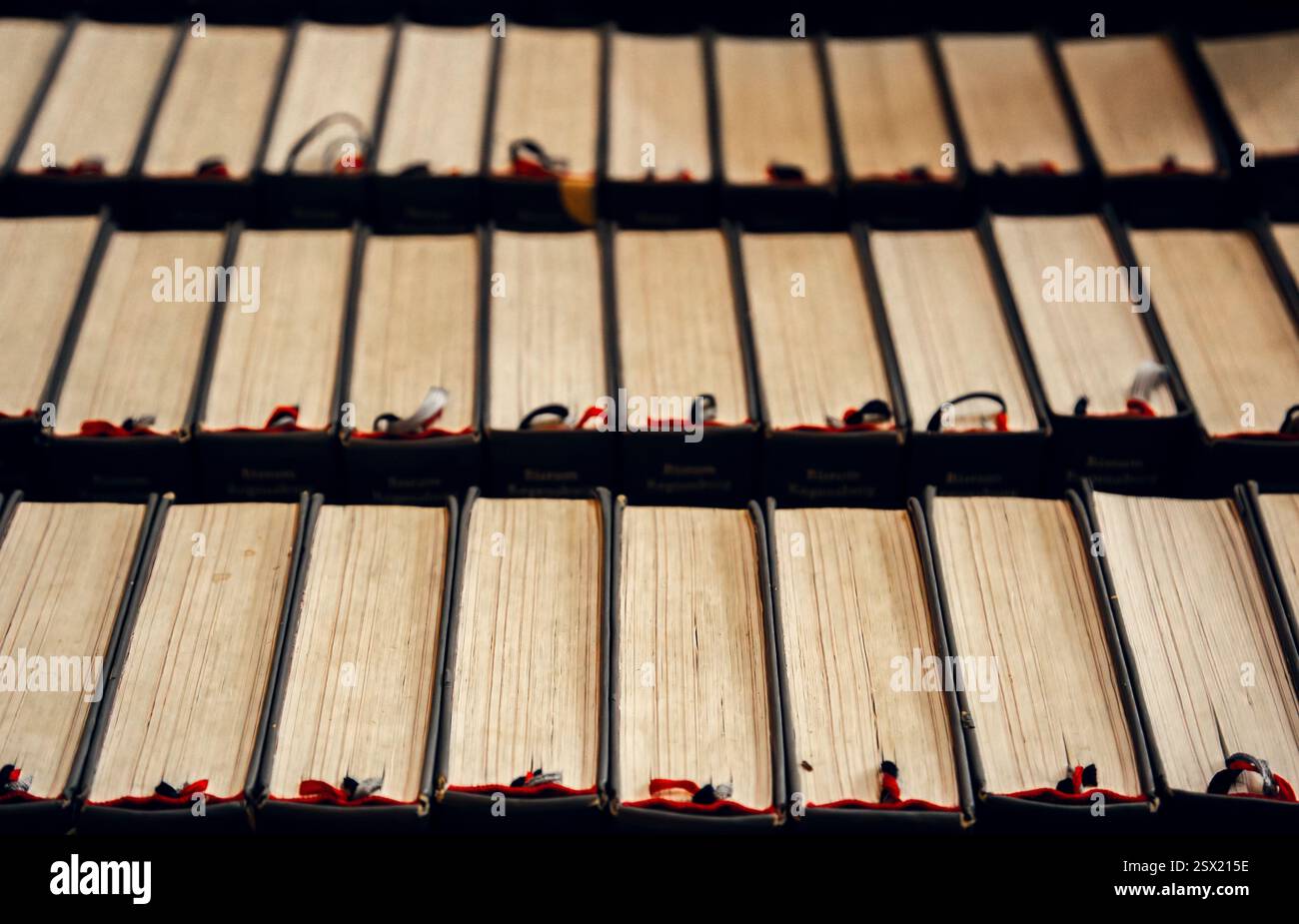 A collection of aged books stacked uniformly with visible bookmarks ...