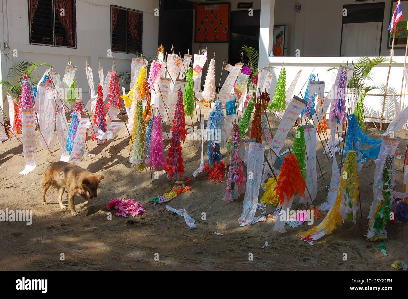 A traditional sand pagoda decorated with vibrant paper flags and ...