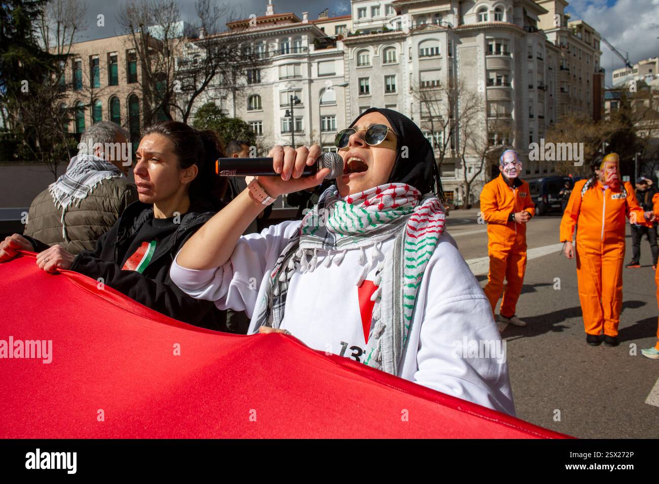 A protester with a kufiya around her neck shouts slogans on a ...