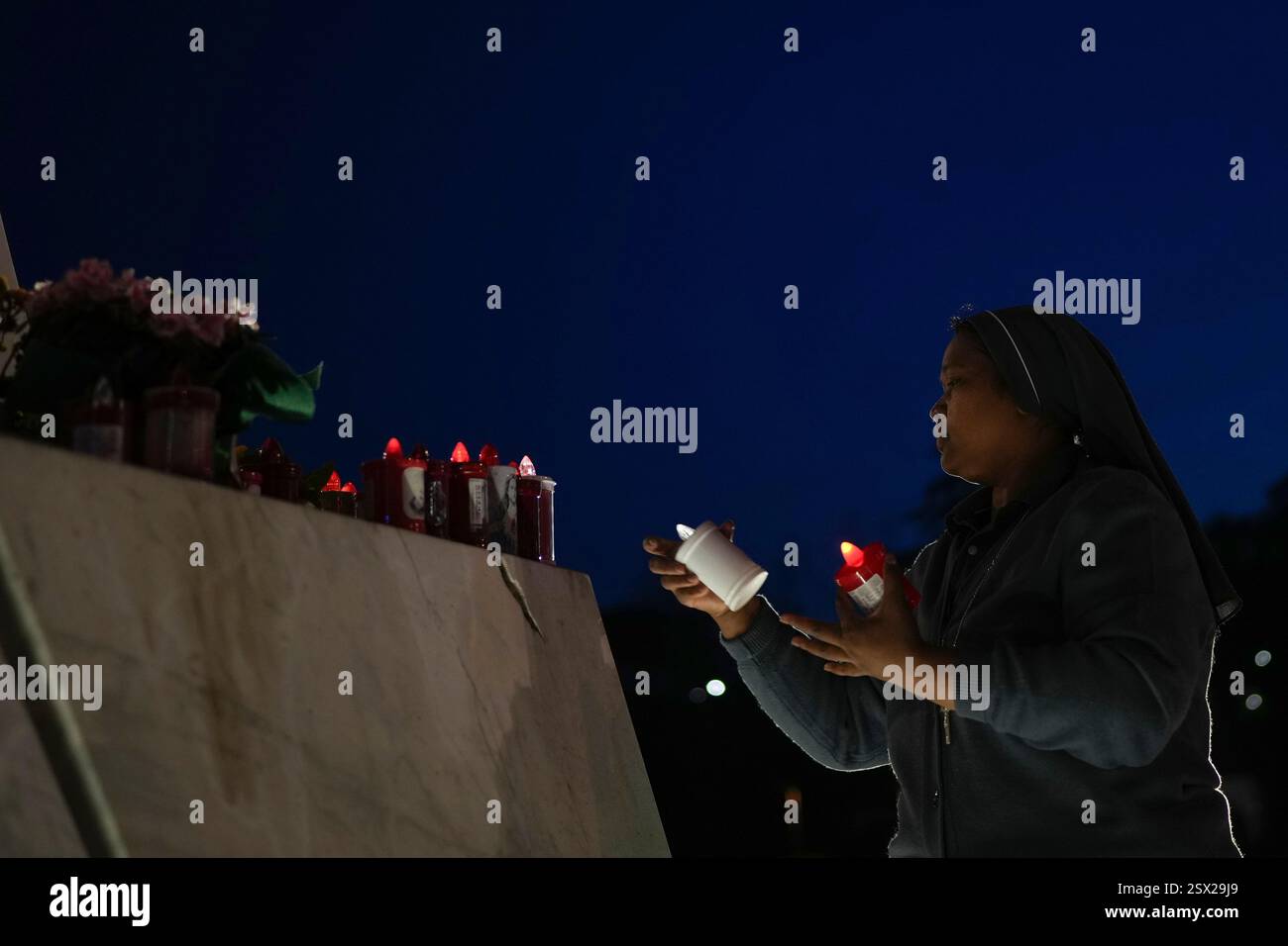 A nun adjusts candles in front of the Agostino Gemelli Polyclinic, in ...