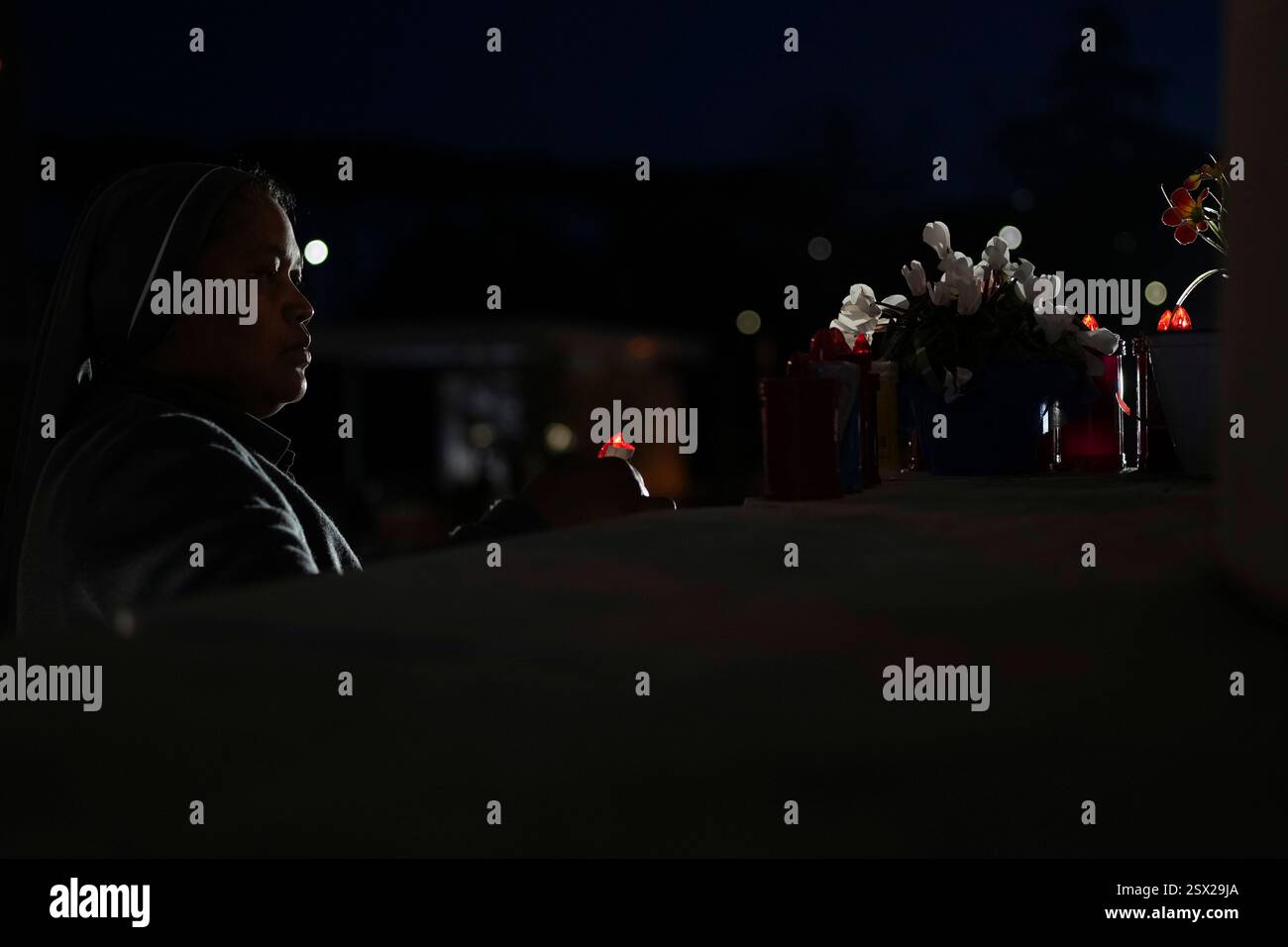 A nun adjusts candles in front of the Agostino Gemelli Polyclinic, in ...