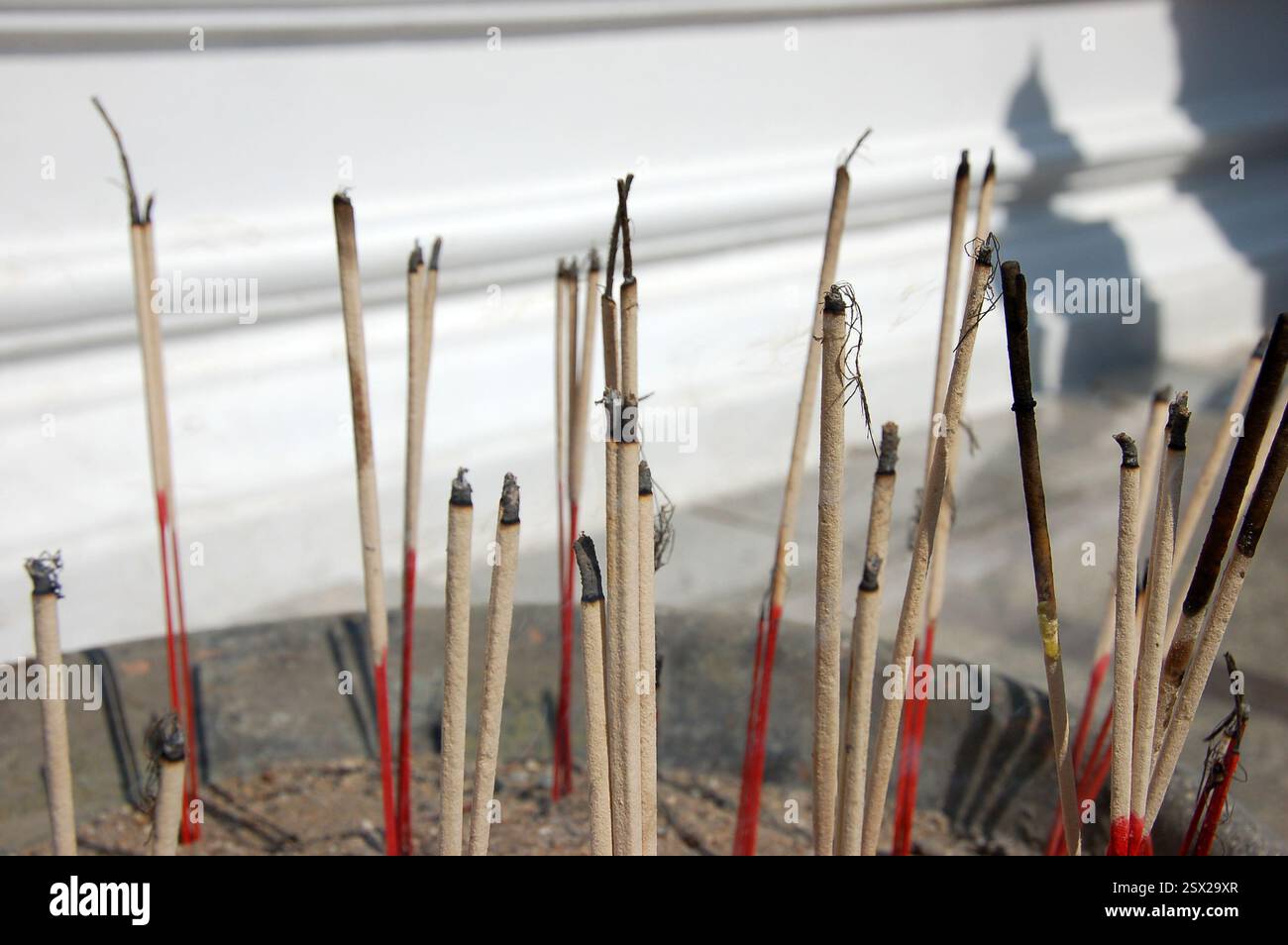 A bowl filled with burning incense sticks, commonly offered at temples ...