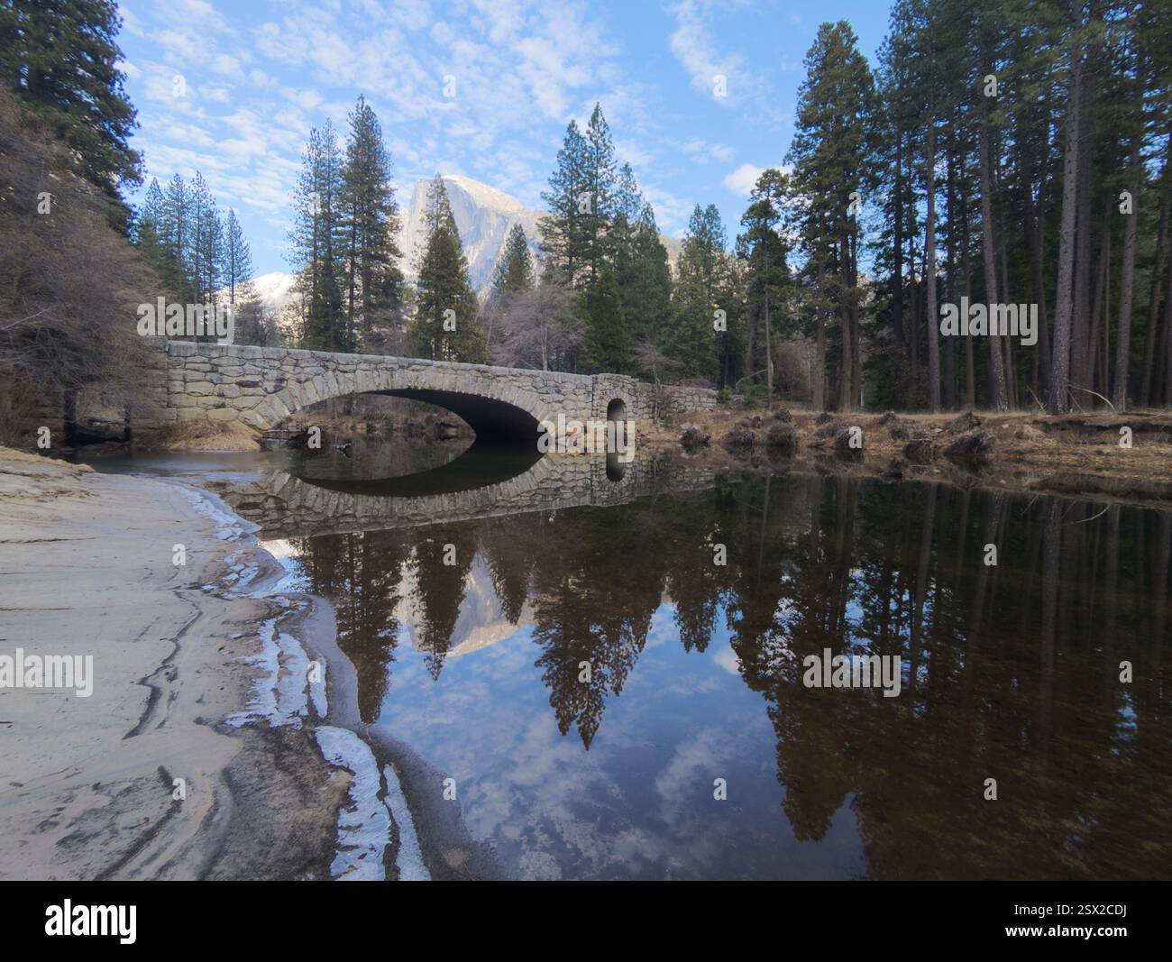 Half dome and a stone bridge reflected in the merced river Stock Photo ...