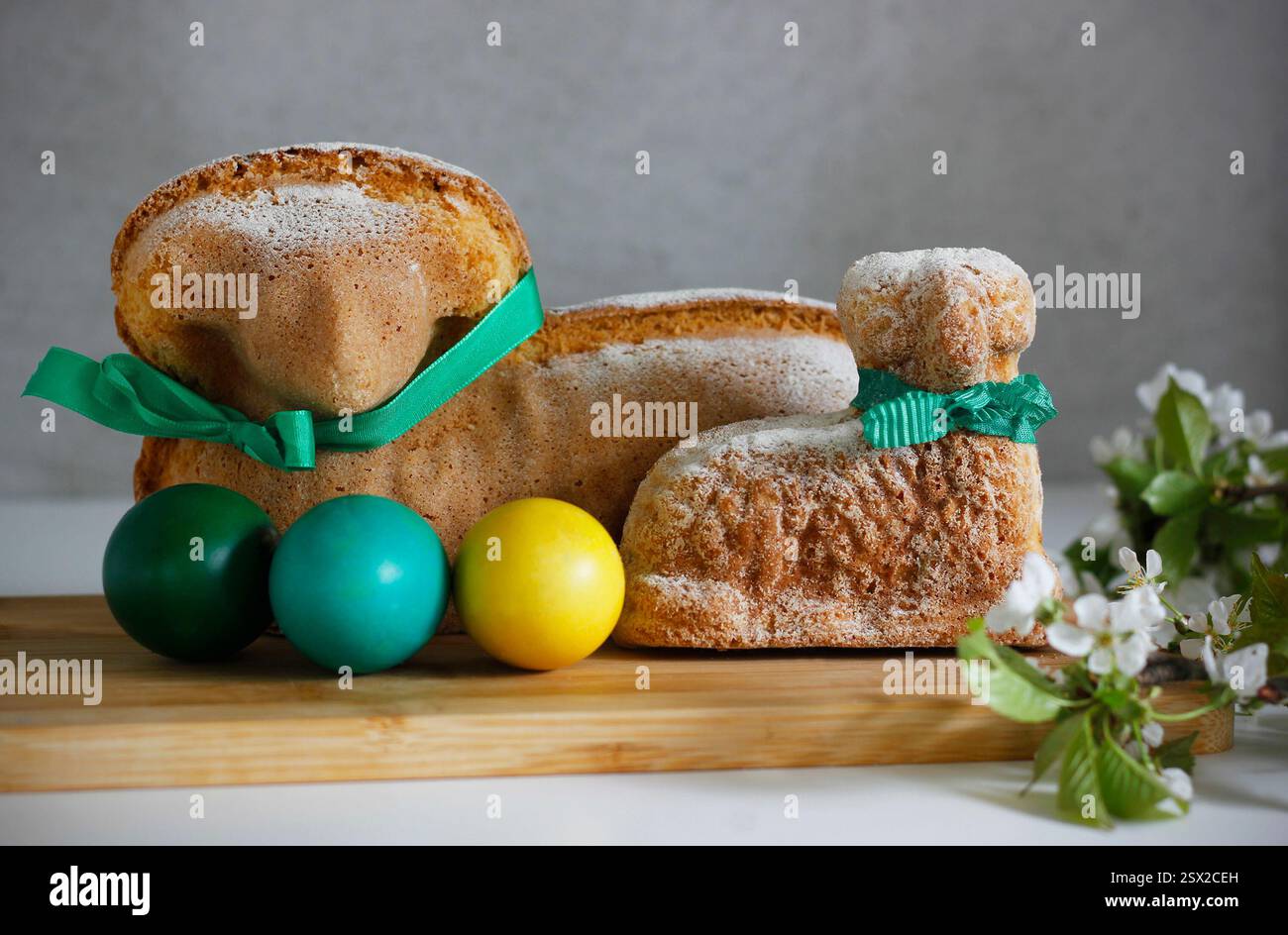 Two Easter lamb cakes with a green ribbon around their necks, three ...