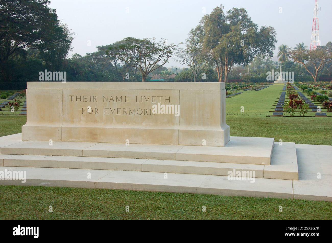 Stone memorial in front of gravestones at the cemetery in Kanchanaburi ...