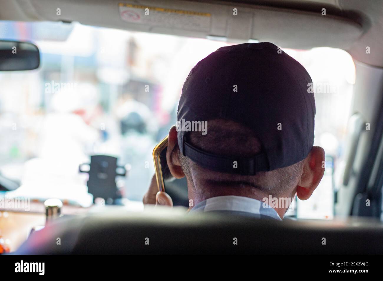 Bangkok, Thailand, February 2025, a minibus driver uses a mobile ...