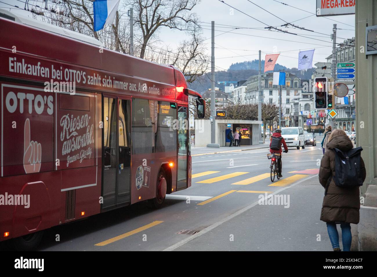 January 13, 2025. Switzerland, Lucerne. Red bus, cars, bicycles and ...