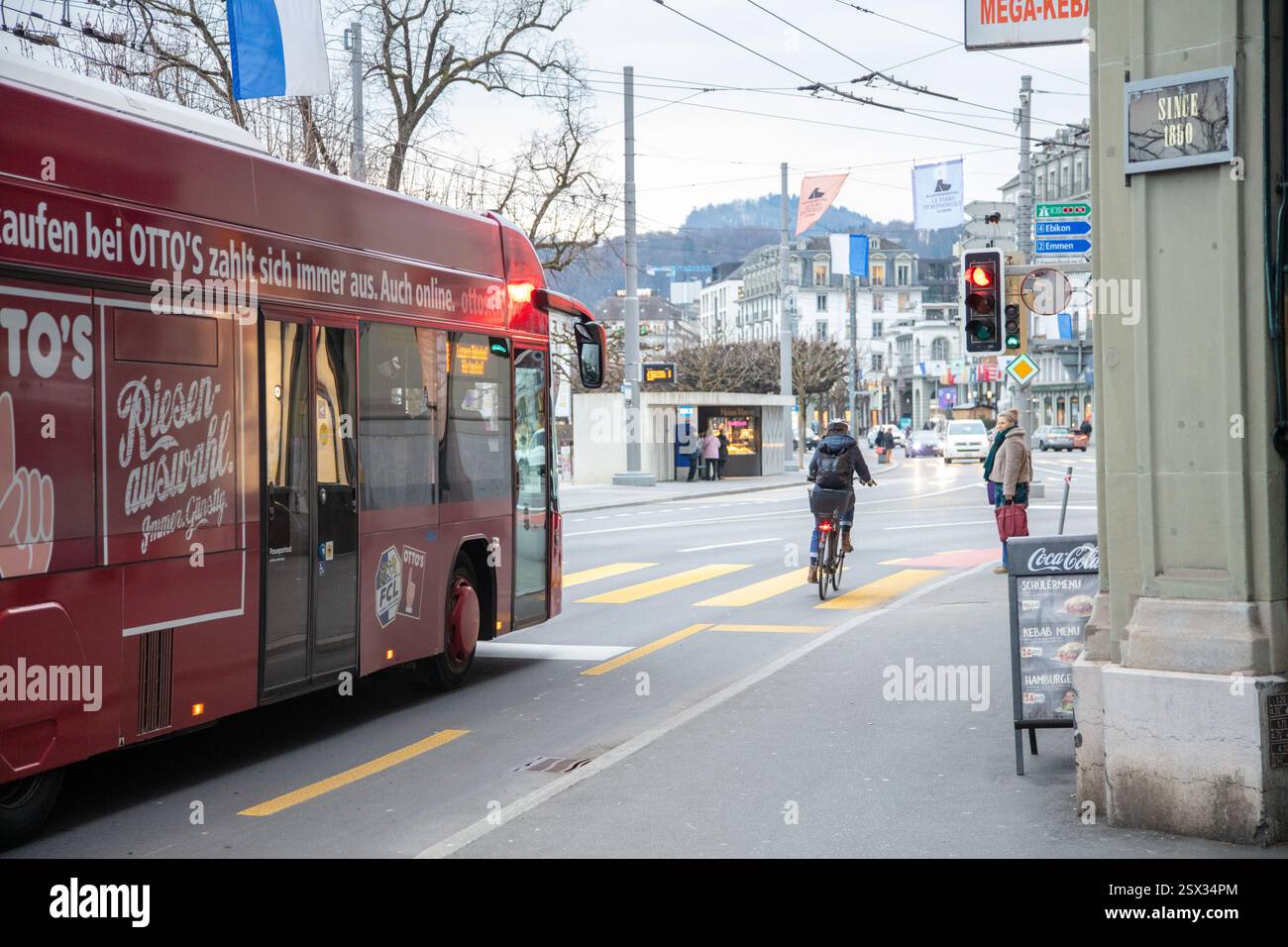 January 13, 2025. Switzerland, Lucerne. Red bus, cars, bicycles and ...