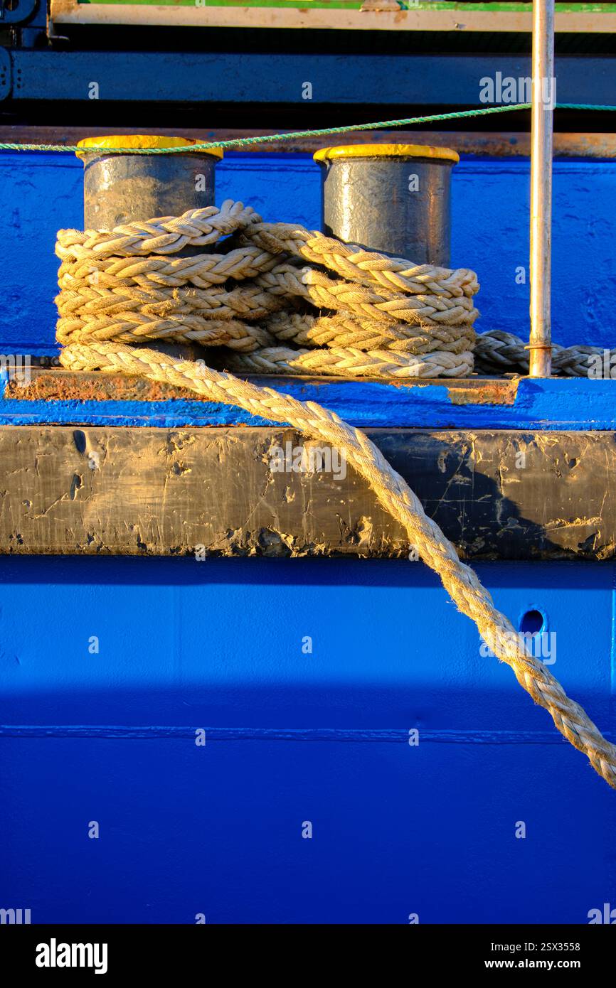 Nautical ropes tightly secured on blue vessel Stock Photo - Alamy