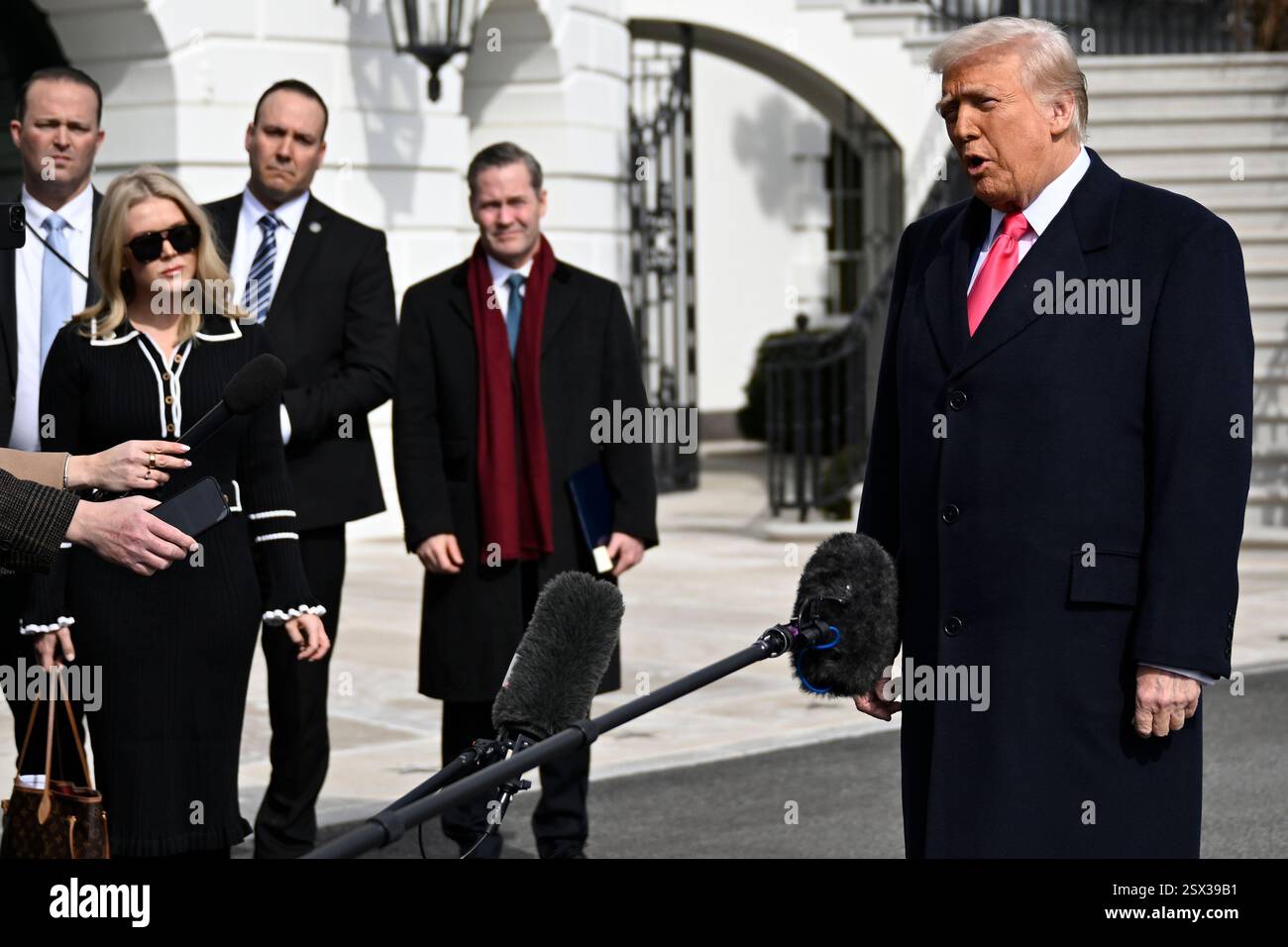 President Donald Trump talks with reporters as he leaves the White ...