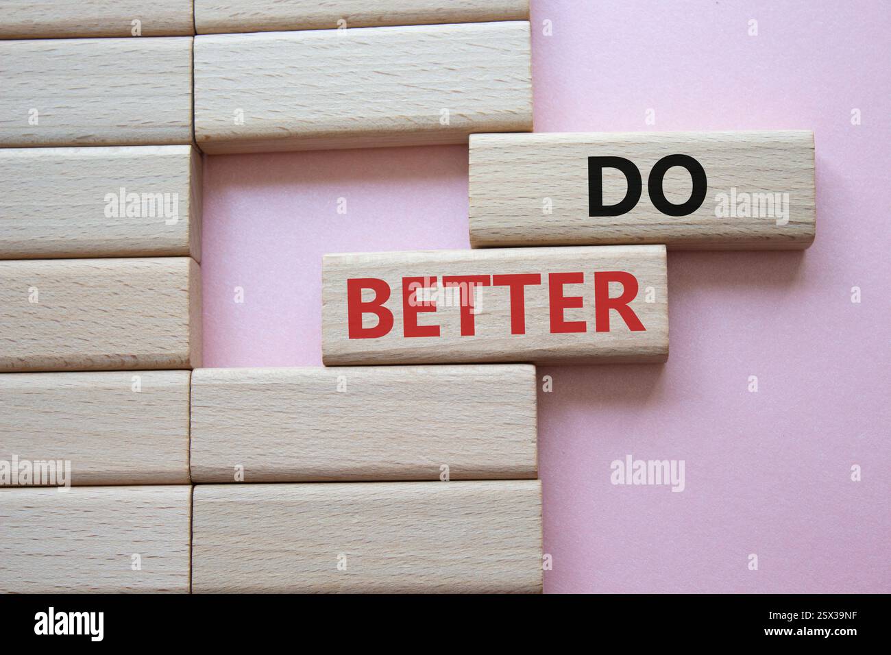 Do better symbol. Wooden blocks with words Do better. Beautiful pink ...
