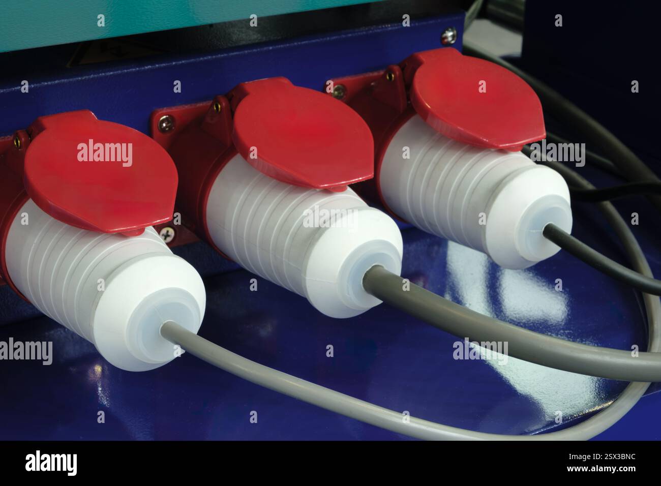 Three white and red electrical plugs are connected to a grey wire. The ...