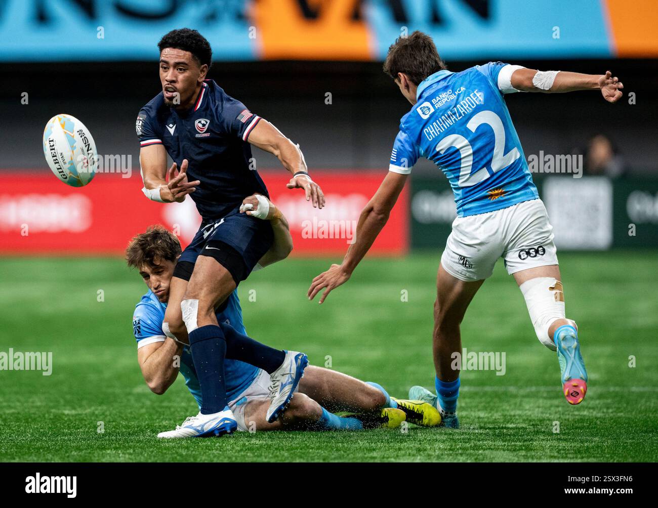 United States' Pita Vi is passes the ball as he is tackled by Uruguay's ...