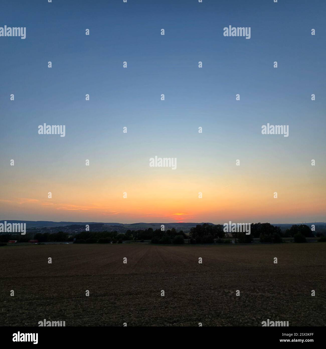 The serene sunset over tranquil fields is beautifully captured in its ...