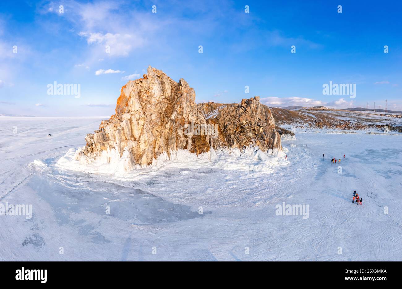 Aerial top view to famous Shamanka rock and small sea covered with snow ...