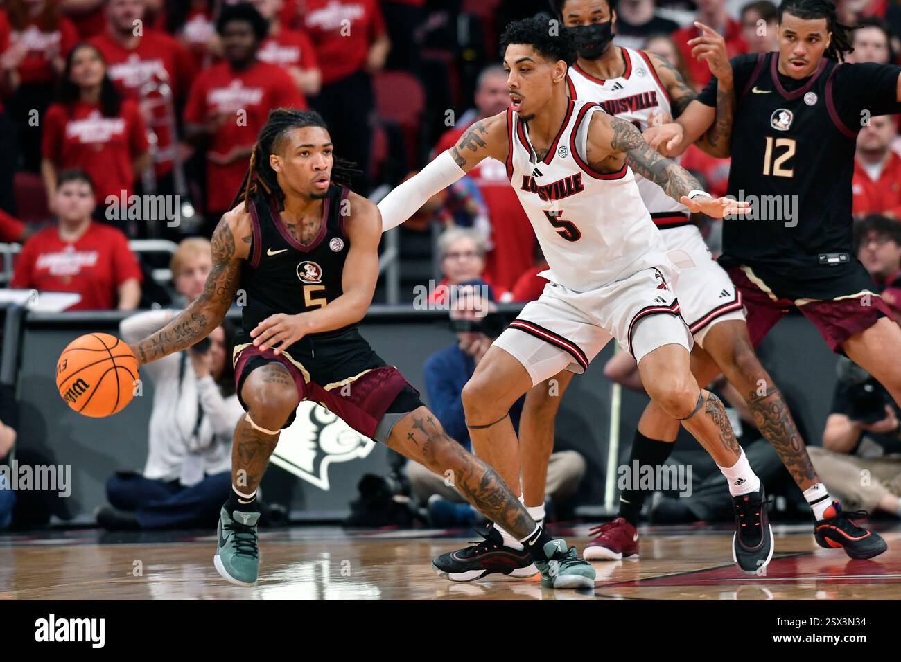 Florida State guard Daquan Davis (5) looks for help as Louisville guard ...