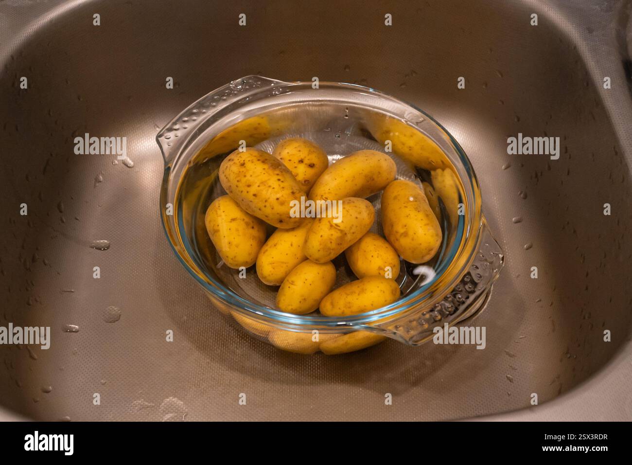 Raw Potatoes in Glass Bowl Soaking in Sink Stock Photo - Alamy