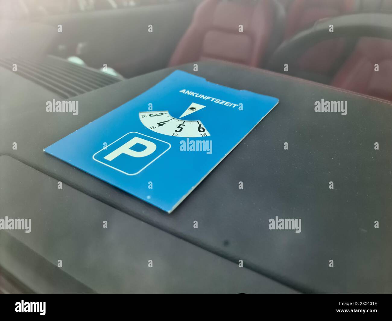 Parking disc displayed on a car dashboard indicating arrival time ...