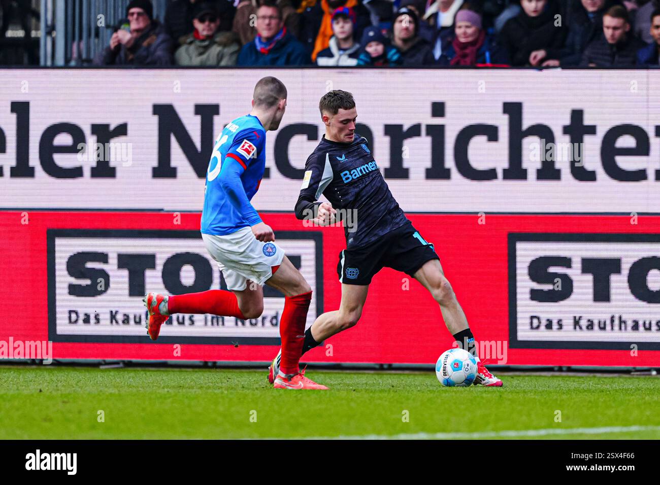 Kiel, Deutschland. 22nd Feb, 2025. David Zec (Holstein Kiel, #26), Florian Wirtz (Bayer 04 ...
