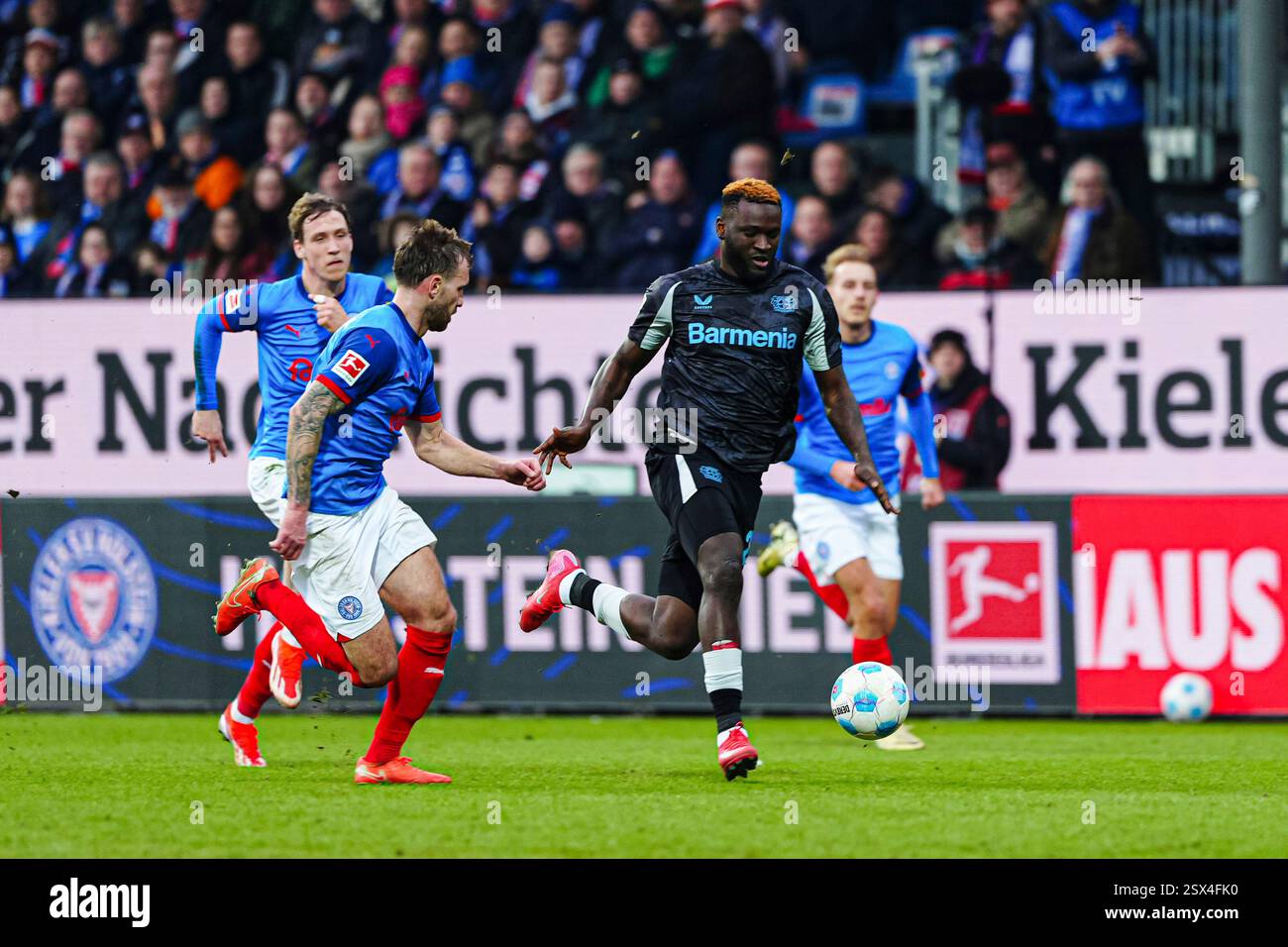 Kiel, Deutschland. 22nd Feb, 2025. Marco Komenda (Holstein Kiel, #03), Victor Boniface (Bayer 04 ...