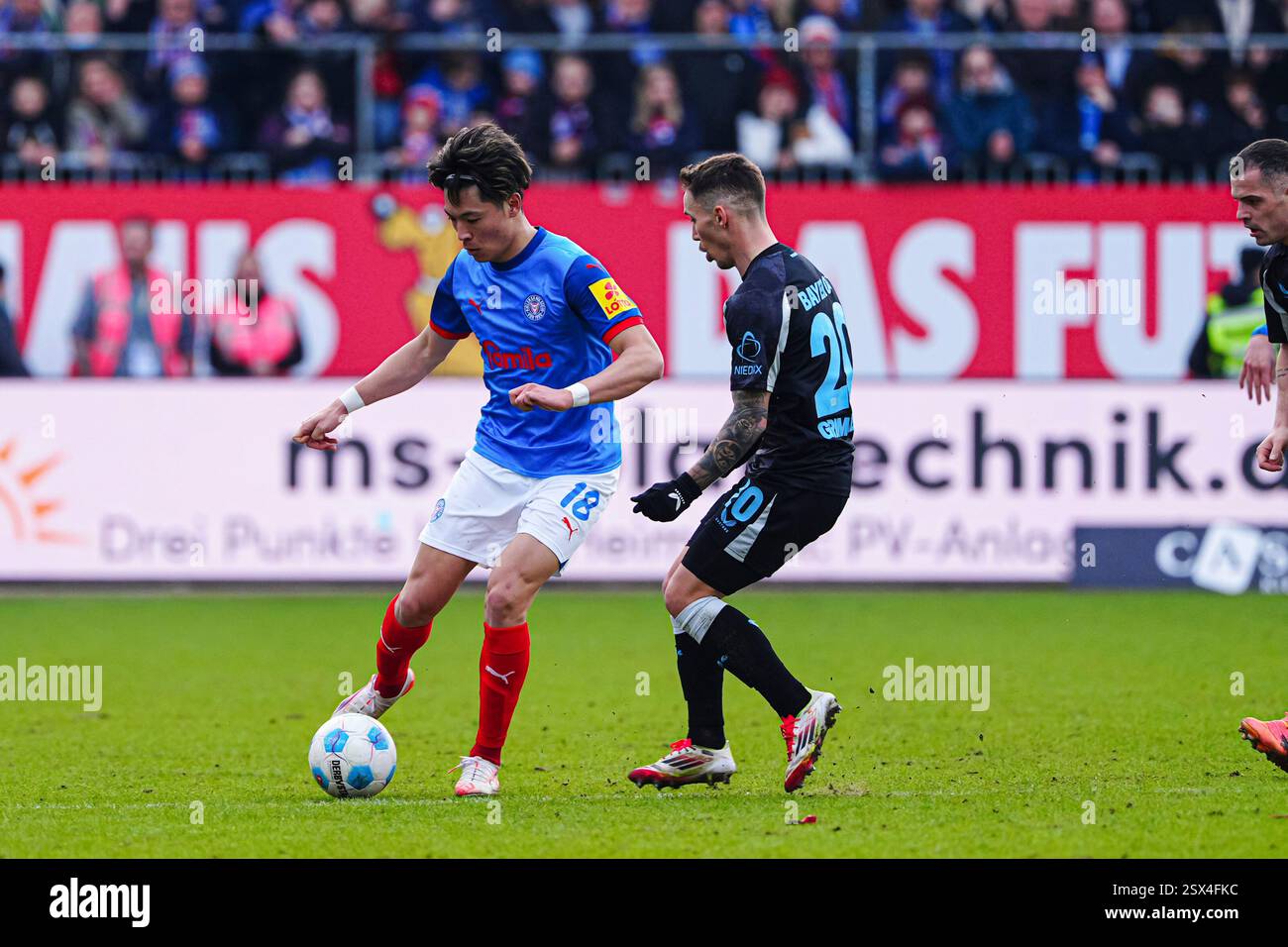 Kiel, Deutschland. 22nd Feb, 2025. Shuto Machino (Holstein Kiel, #18), Alejandro Grimaldo (Bayer ...