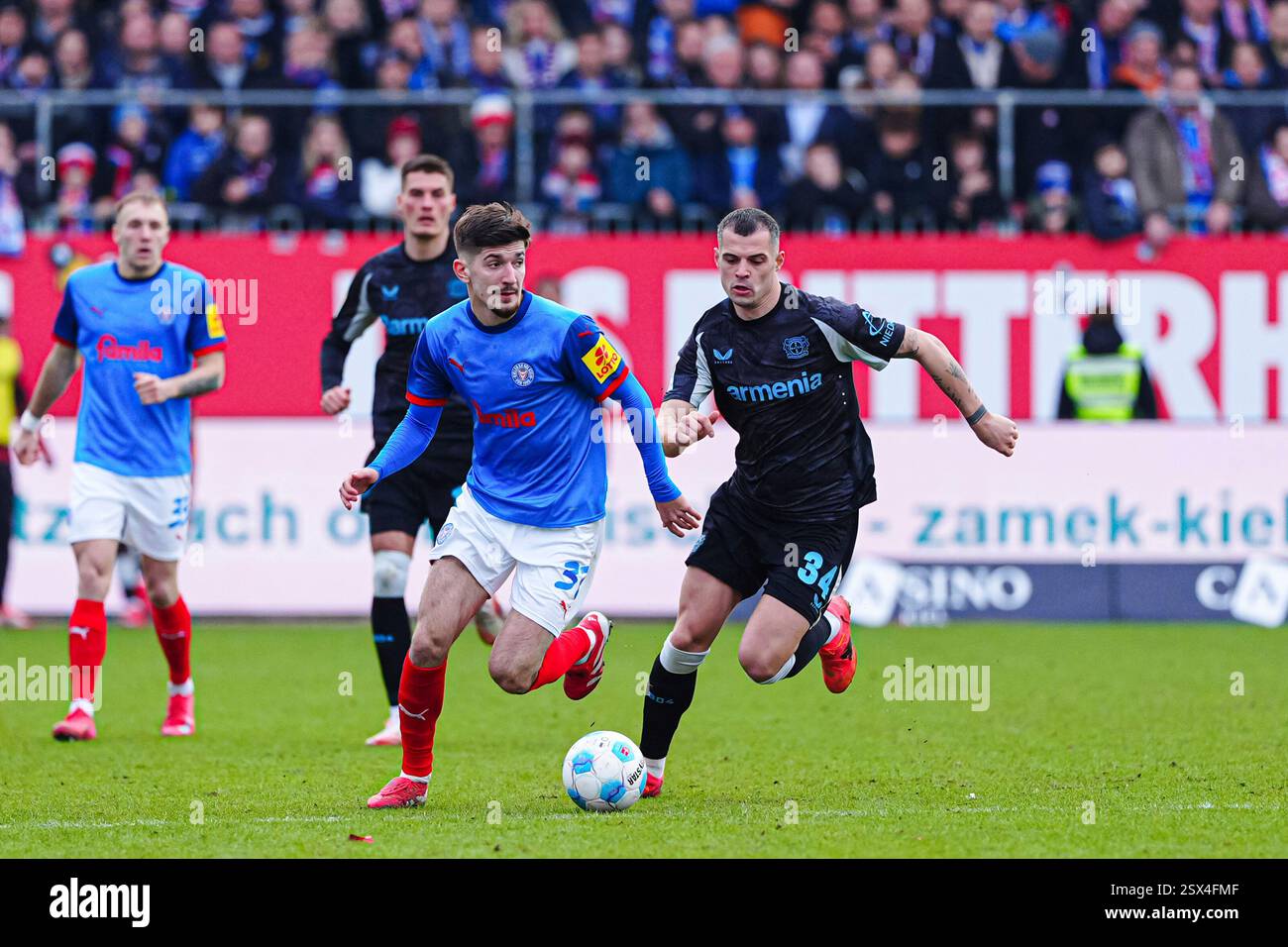 Kiel, Deutschland. 22nd Feb, 2025. Armin Gigovic (Holstein Kiel, #37), Granit Xhaka (Bayern 04 ...