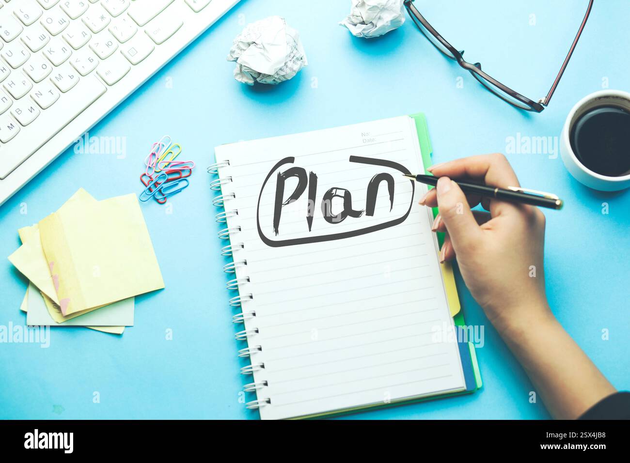 woman written plan on notepad with keyboard and stationary on table ...