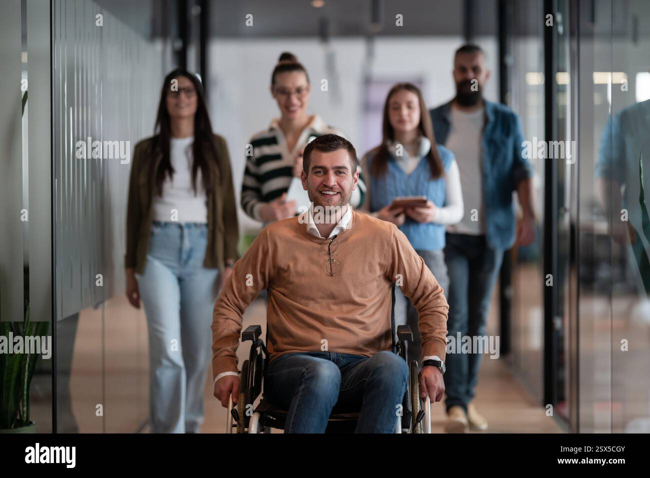A businessman with disability in a wheelchair is surrounded by ...