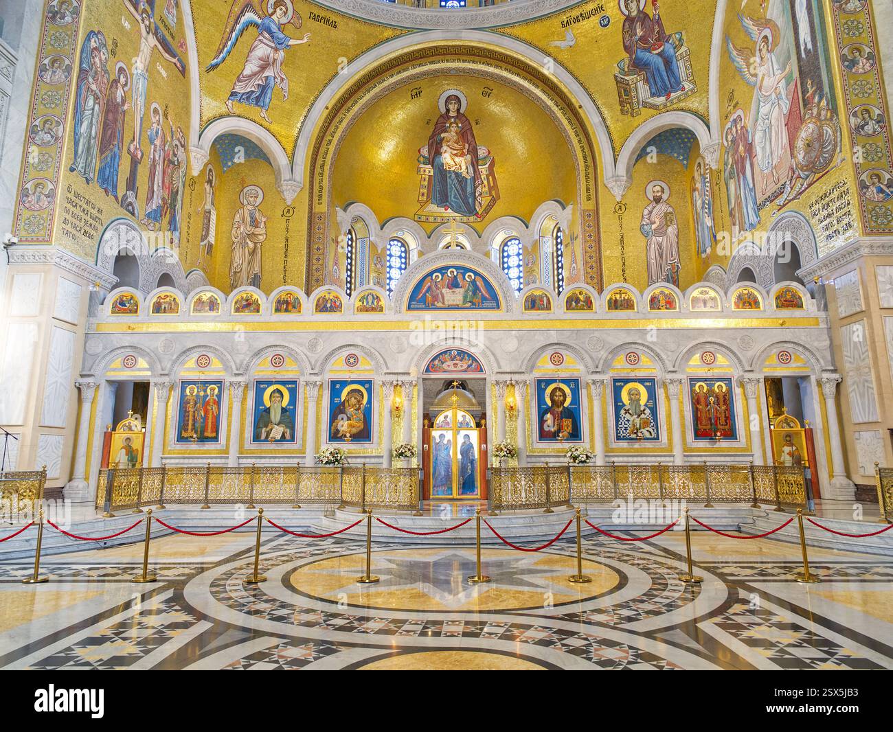 Lavishly decorated Orthodox church interior with golden mosaics, iconostasis, and domed ceiling ...