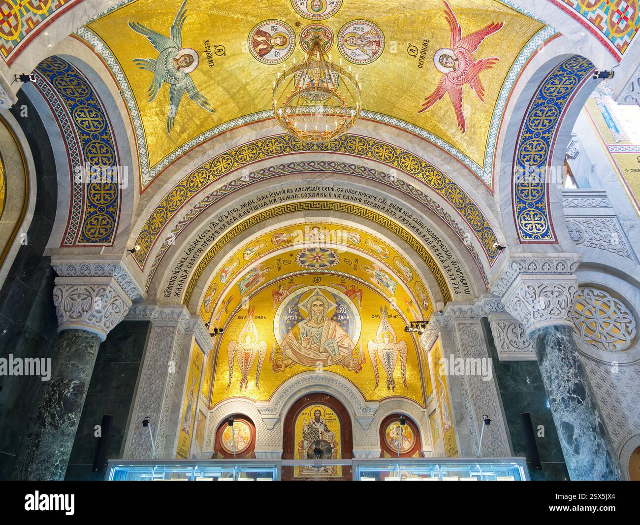 Richly decorated church interior featuring golden mosaics, arches, and religious iconography ...