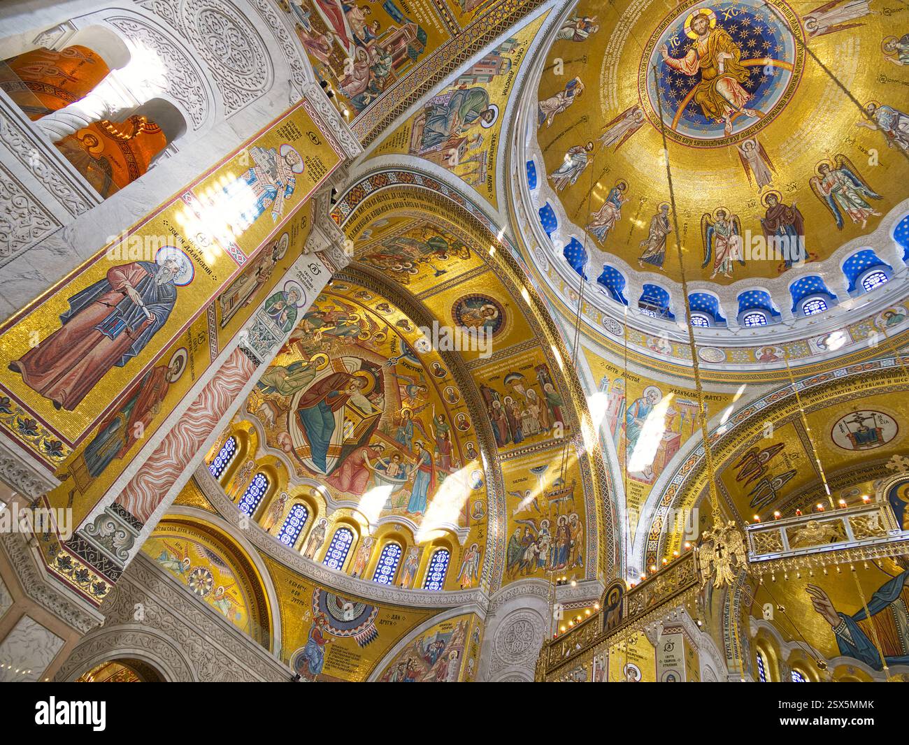 Interior of a Byzantine-style church with elaborate golden mosaics, domes, and religious artwork ...