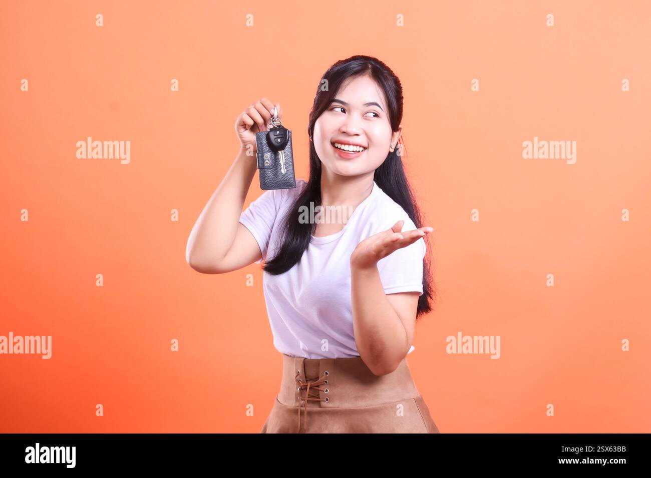 Excited Asian woman showing off her new car keys with a big smile ...