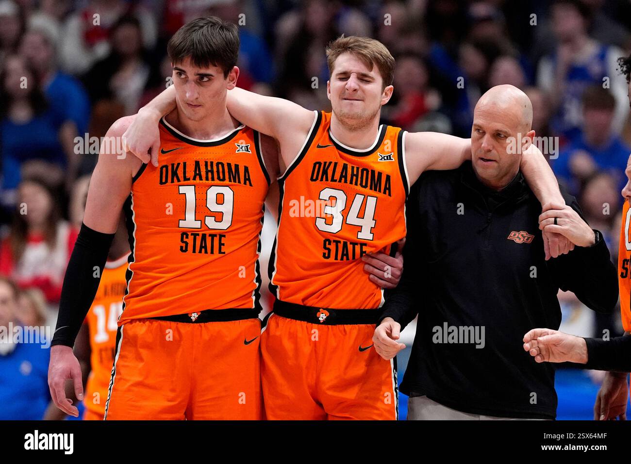 Oklahoma State forward Tyler Caron (34) is helped off the court by ...