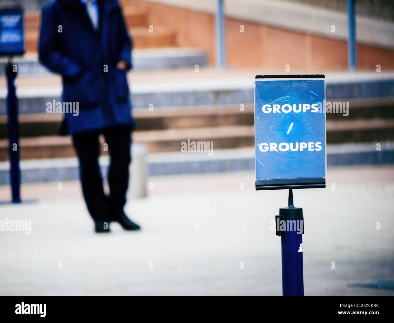 A blue sign labeled GROUPS GROUPES stands in the foreground, directing ...