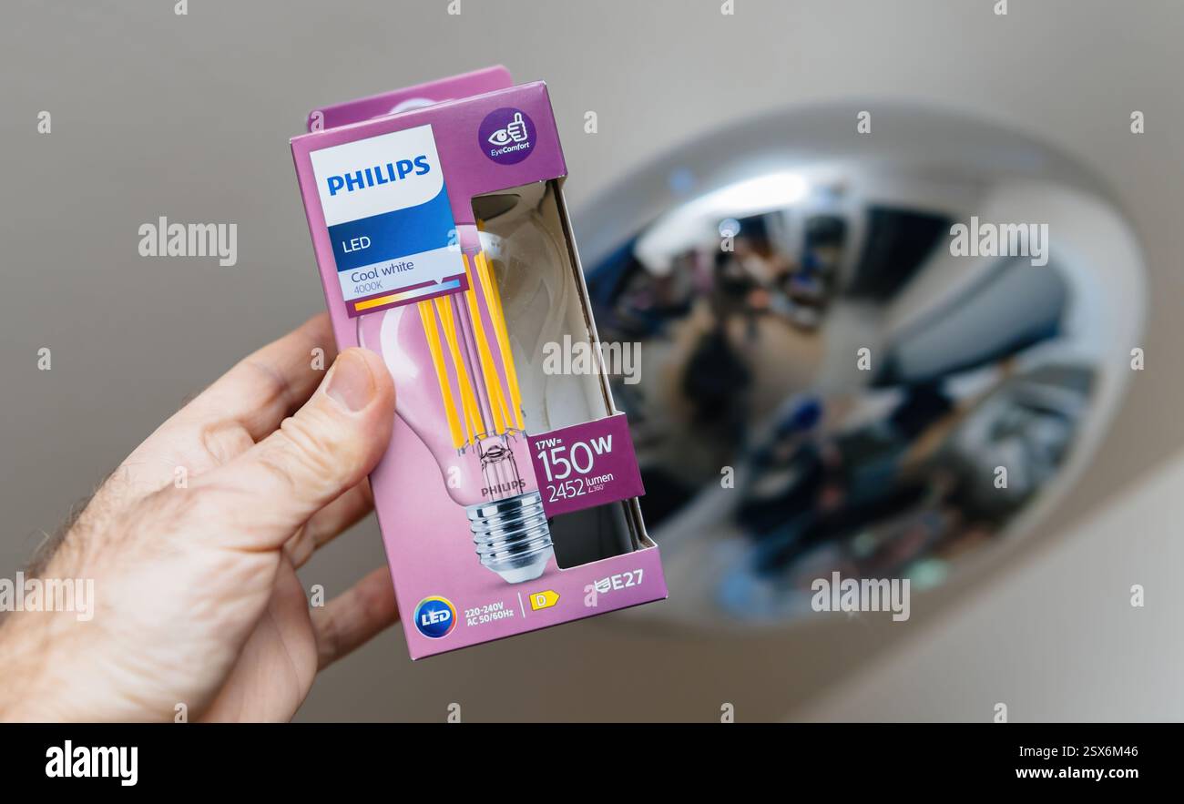 Paris, France - Feb 17, 2025: A person holds a Philips LED filament ...