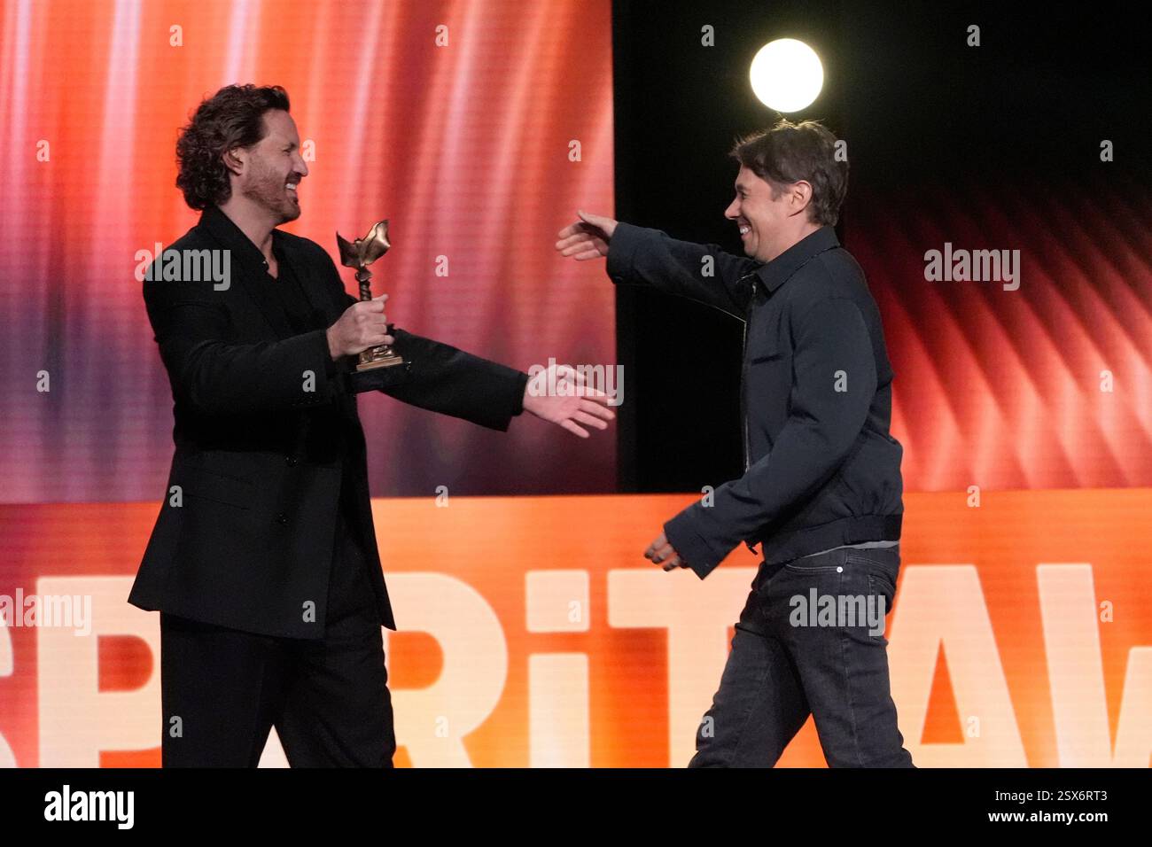 Edgar Ramirez, left, presents the award for best director to Sean Baker ...