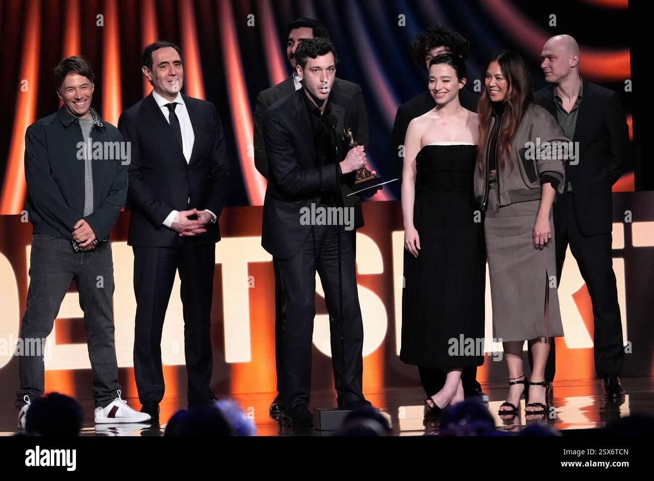 Alex Coco, center, accepts the award for best feature for "Anora ...