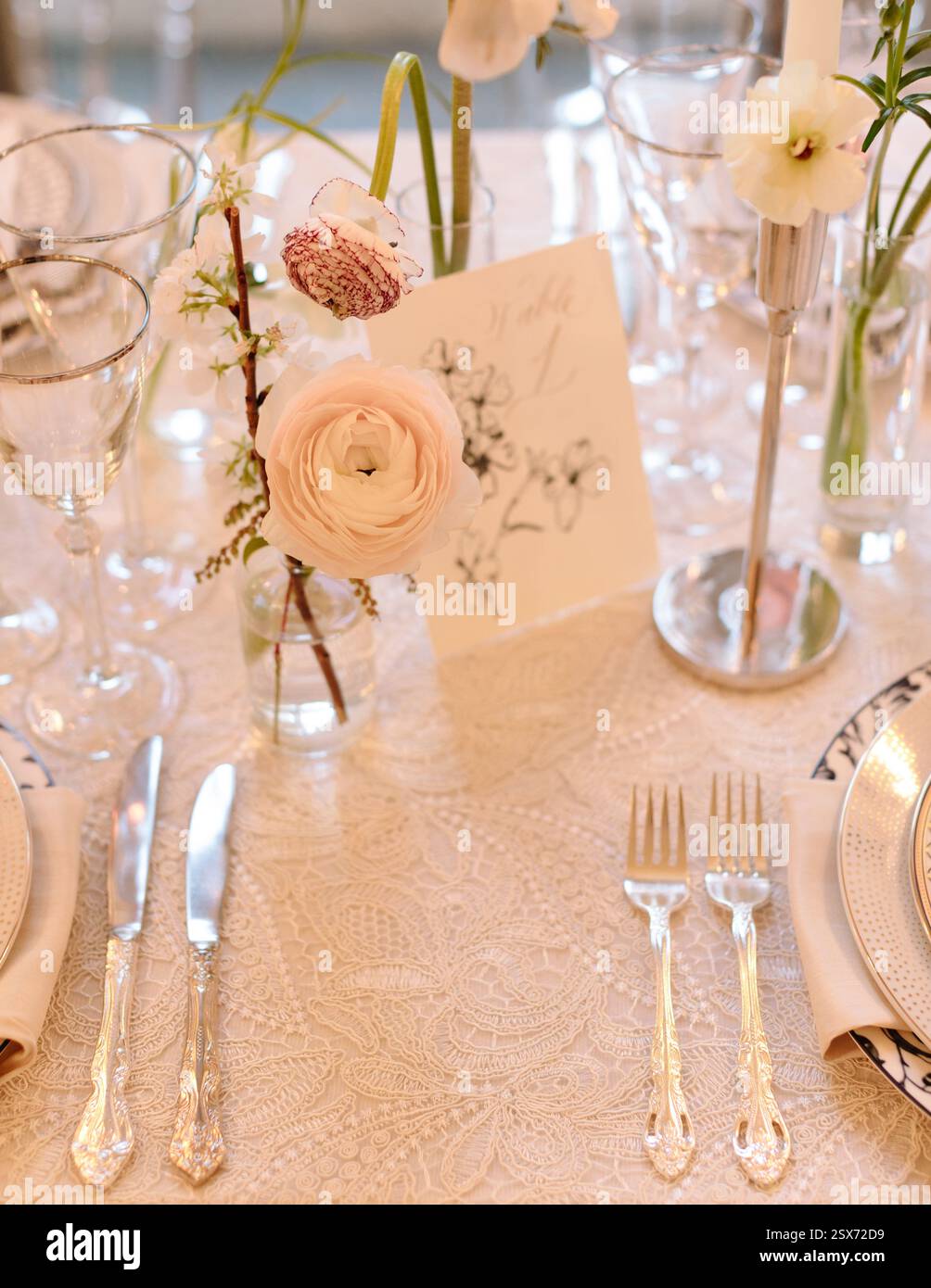 Table set with delicate flowers, sparkling glassware, and elegant ...