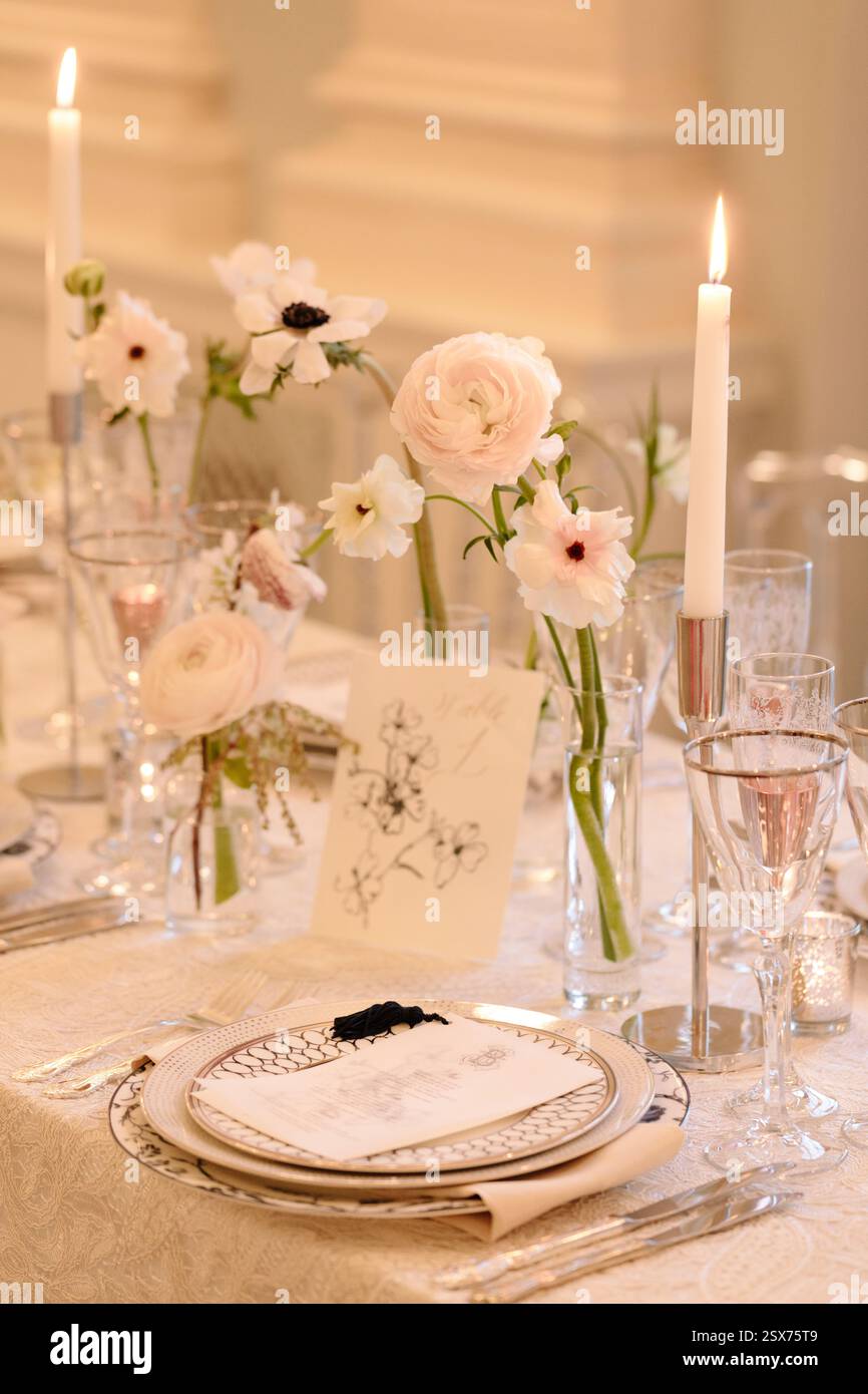 A beautifully set table with flowers, elegant dinnerware, and soft ...