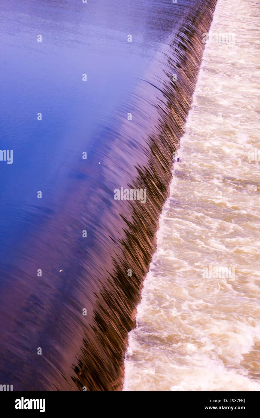 The water is flowing over a waterfall, creating a beautiful and serene ...