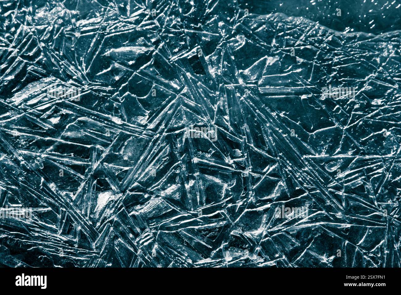 The image is of ice with a blue tint. The ice is jagged and has a rough ...