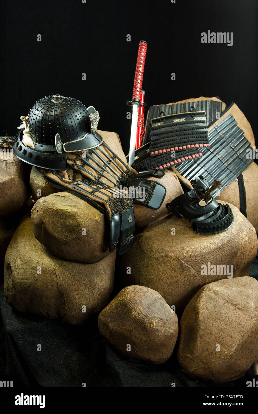 Samurai warrior's helmet and sword are displayed on a pile of rocks ...