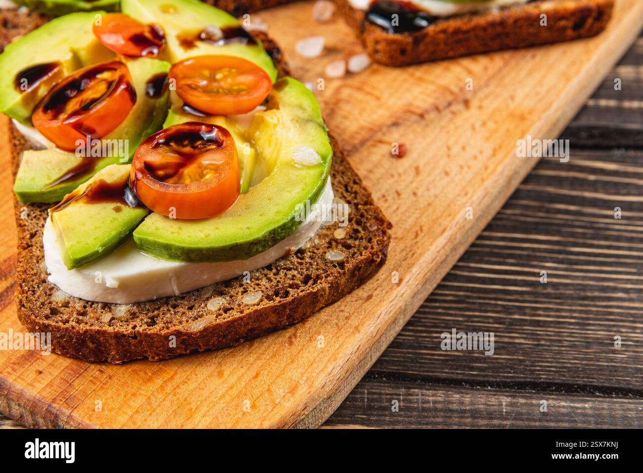 A vibrant dish featuring fresh slices of avocado and cherry tomatoes ...