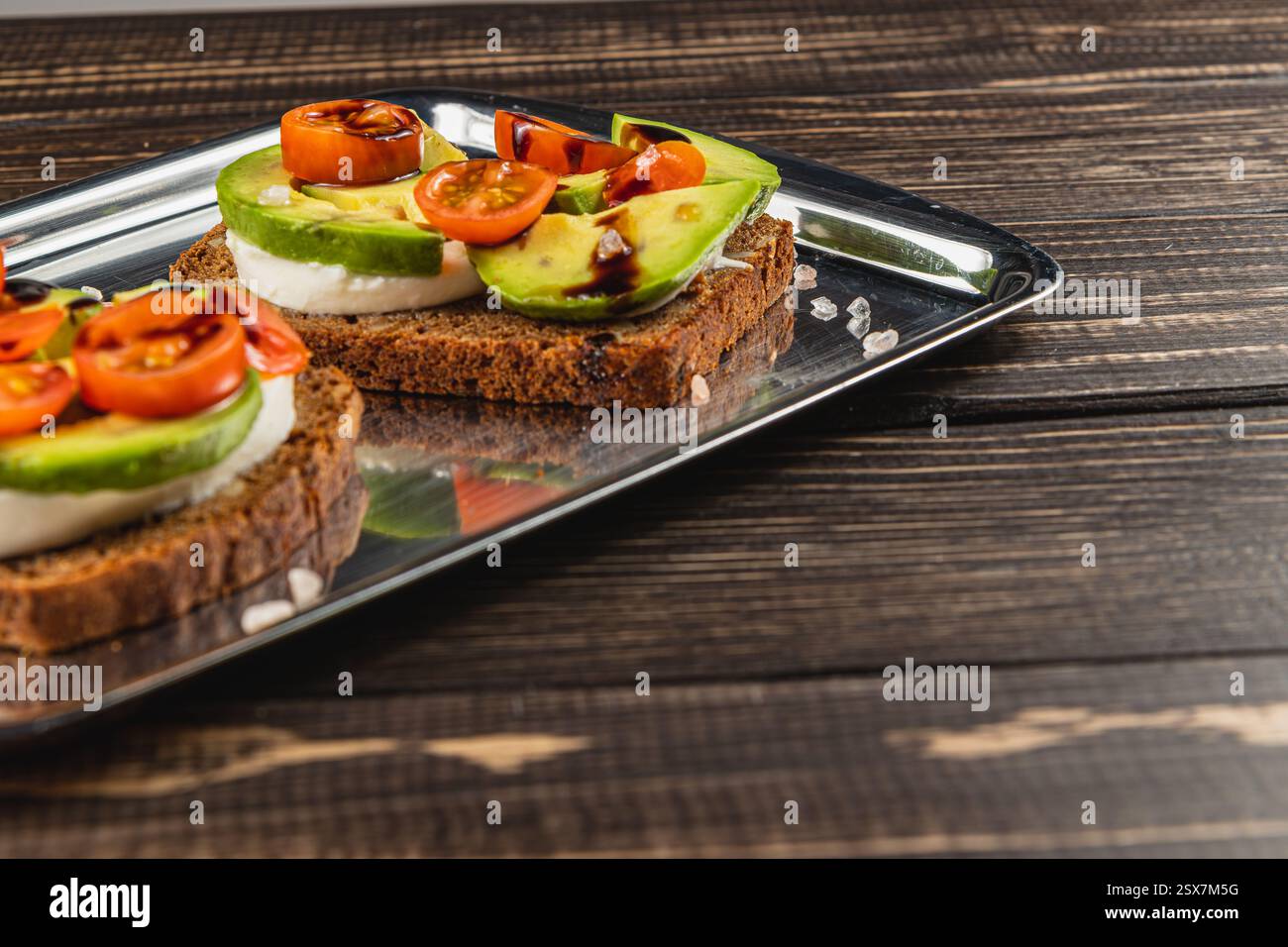 Freshly prepared open-faced sandwiches are served on a metal tray ...