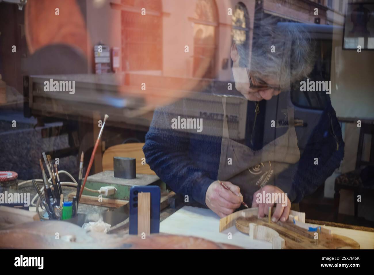 Cremona, Italy February 9th 2025 Skilled artisan focuses on woodworking ...
