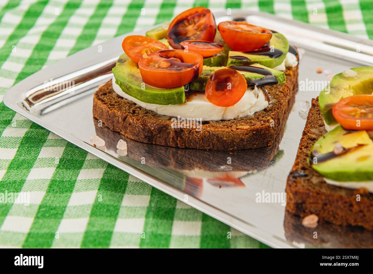 Freshly prepared open-faced sandwiches sit on a metal tray. Slices of ...