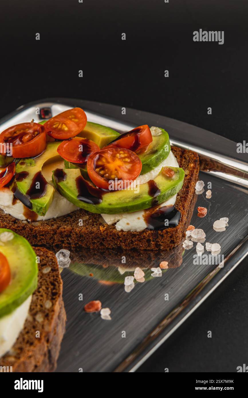 An open-faced sandwich features layers of creamy spread, avocado slices ...