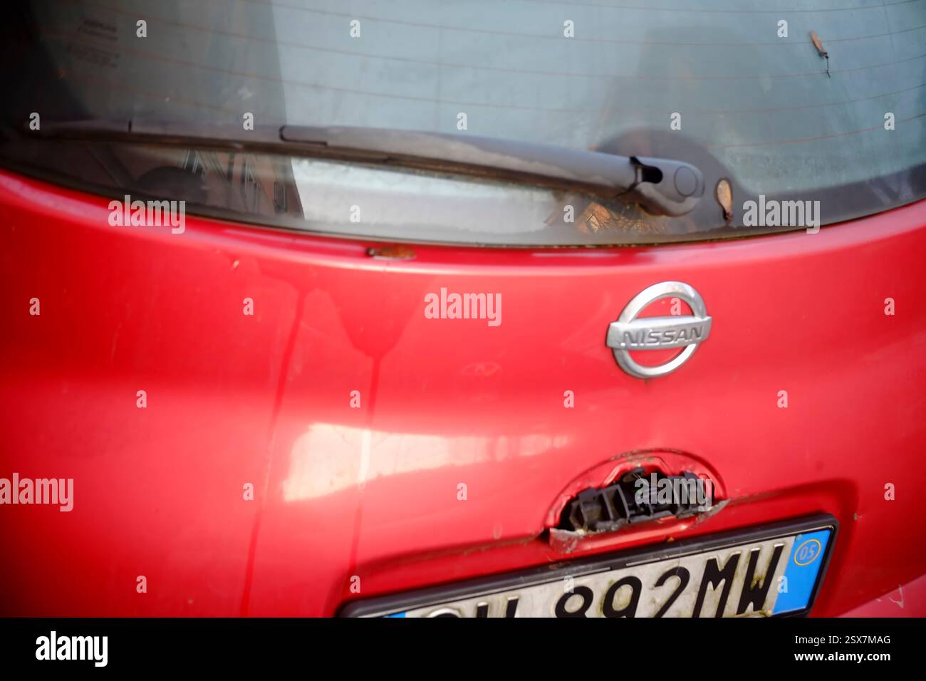 Cremona, Italy February 9th 2025 Broken handle on the red Nissan Micra ...