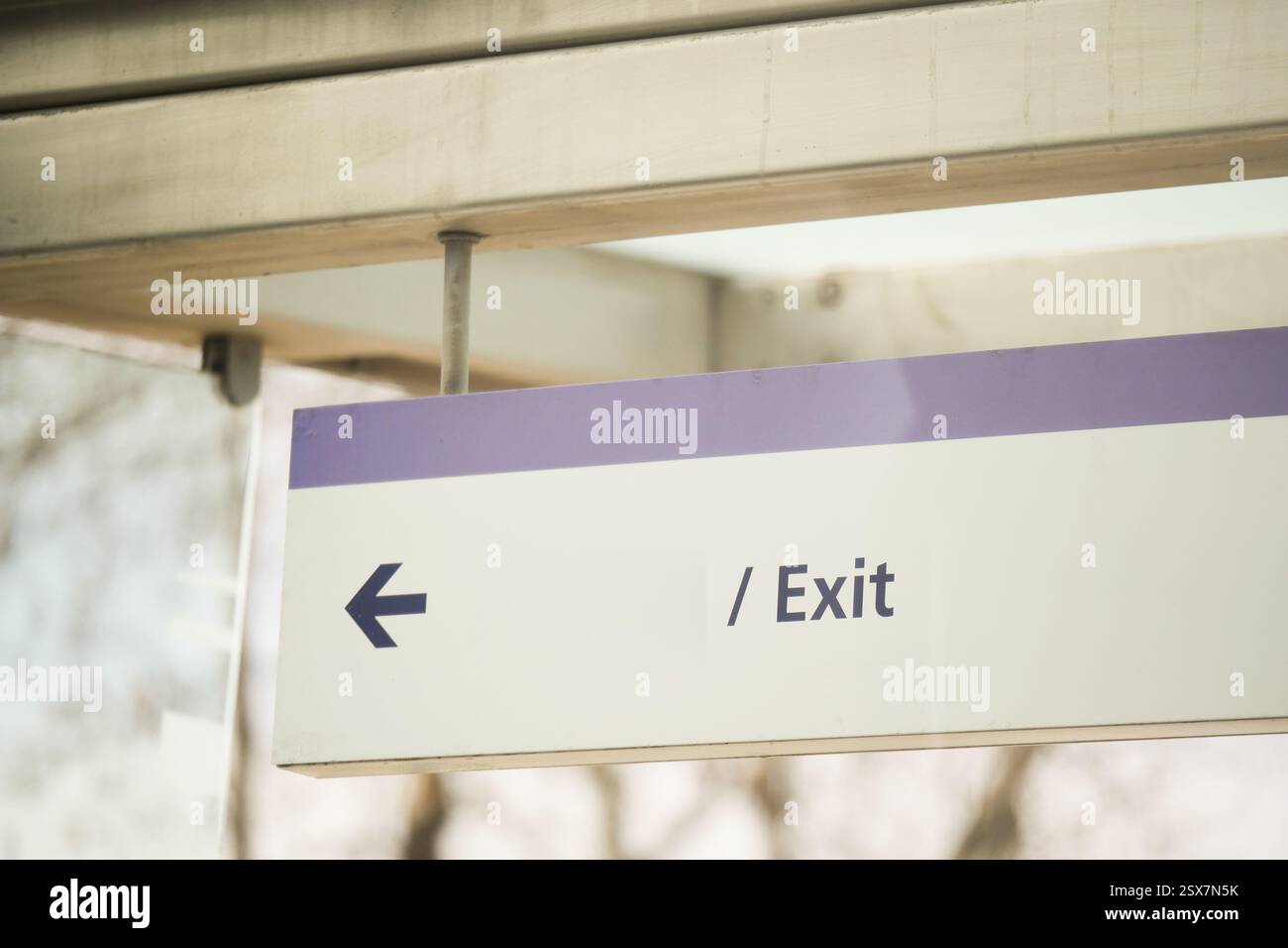 Sign pointing left toward exit in a public space Stock Photo - Alamy