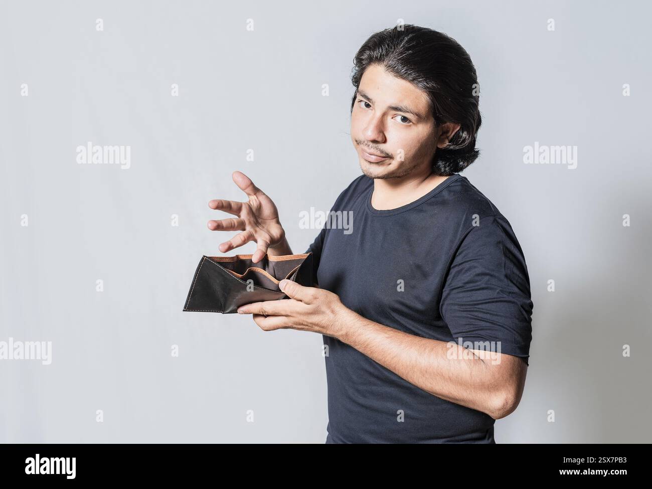 Young man with financial crisis holding wallet isolated. Sad man ...